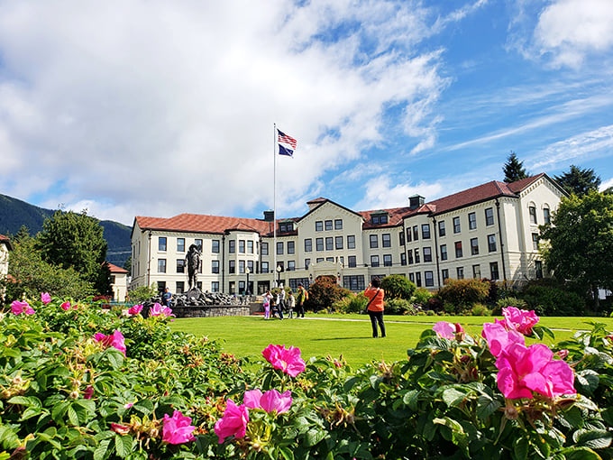 A postcard-perfect scene: Baranof Castle's grand facade, framed by vibrant flowers and majestic mountains. History never looked so inviting!