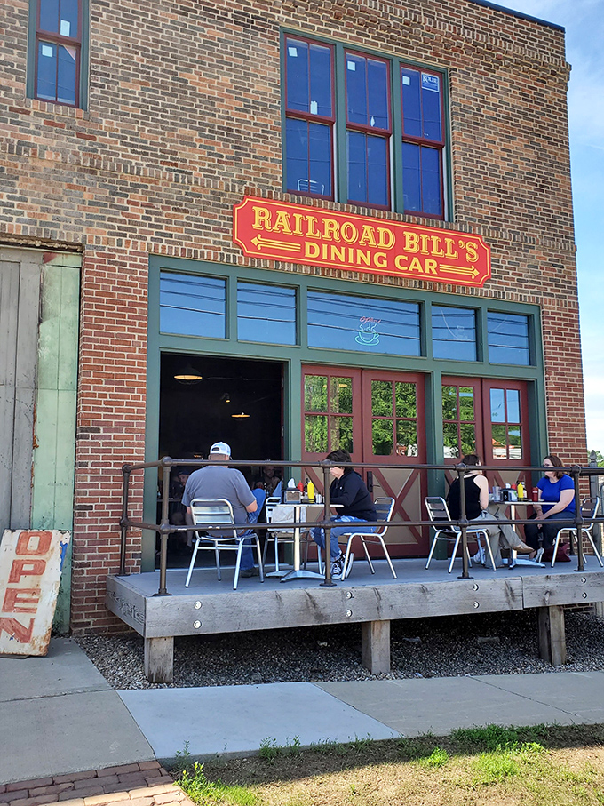 All aboard the flavor express! Railroad Bill's Dining Car beckons with its charming brick facade and inviting wooden deck, promising a journey through time and taste.