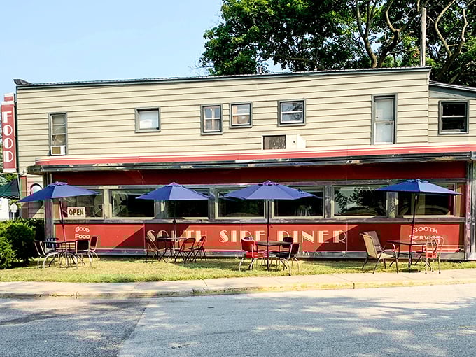 Step back in time! This retro-chic diner exterior is like a portal to the 1950s, complete with cherry-red accents and inviting blue umbrellas.