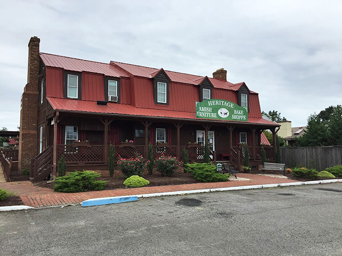 The red metal roof and welcoming wooden porch of Heritage Bake Shoppe stand as a rustic oasis amid Virginia Beach's coastal landscape.
