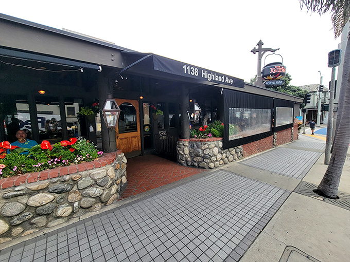 A stone's throw from paradise! The Kettle's charming exterior beckons with its rustic stonework and vibrant flower boxes, promising comfort food with a side of coastal charm.