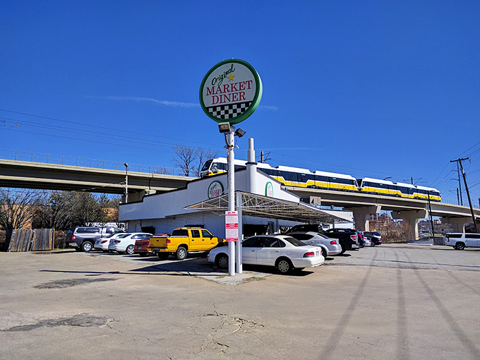 The iconic circular sign of Original Market Diner stands tall against the Dallas sky, a beacon for breakfast enthusiasts since the 1950s.