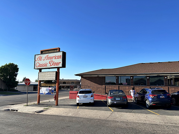 The classic roadside sign beckons like a lighthouse for hungry travelers. Against that perfect Utah blue sky, it promises comfort food salvation just off the highway.