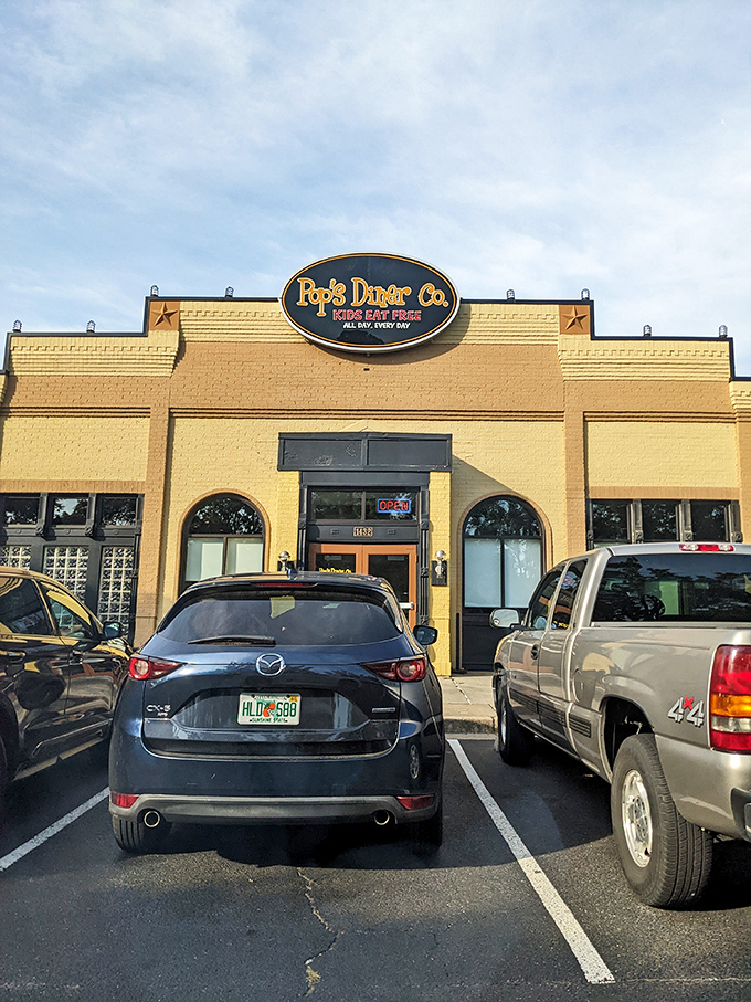 The sunshine-yellow exterior of Pop's Diner Co. stands out like a beacon for breakfast lovers, promising comfort food salvation with its cheerful "Kids Eat Free" sign.