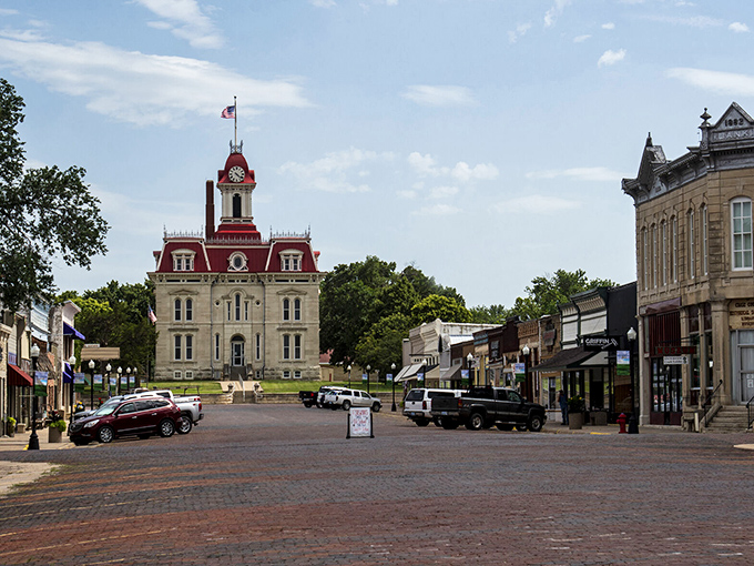 The Chase County Courthouse stands like a Victorian sentinel at the end of Broadway Street, its red mansard roof and limestone walls creating an unforgettable silhouette against the Kansas sky.