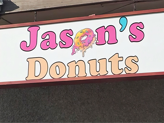 A sign that promises sweet dreams! Jason's Donuts beckons with its playful logo, like a Willy Wonka factory for the breakfast crowd.