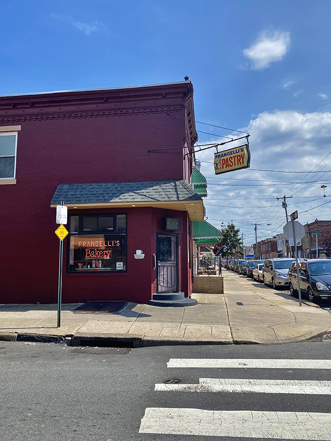 A red brick facade that screams "hidden gem." Frangelli's neon sign promises sweet salvation, while the "Hot Coffee" beckons like a siren's call to caffeine addicts.