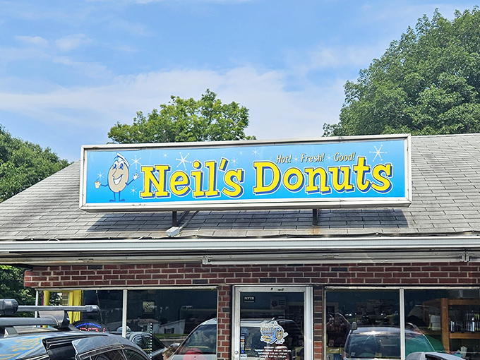 Welcome to donut paradise! Neil's Donuts stands proud, its cheerful sign beckoning like a sugary lighthouse to weary travelers and locals alike.