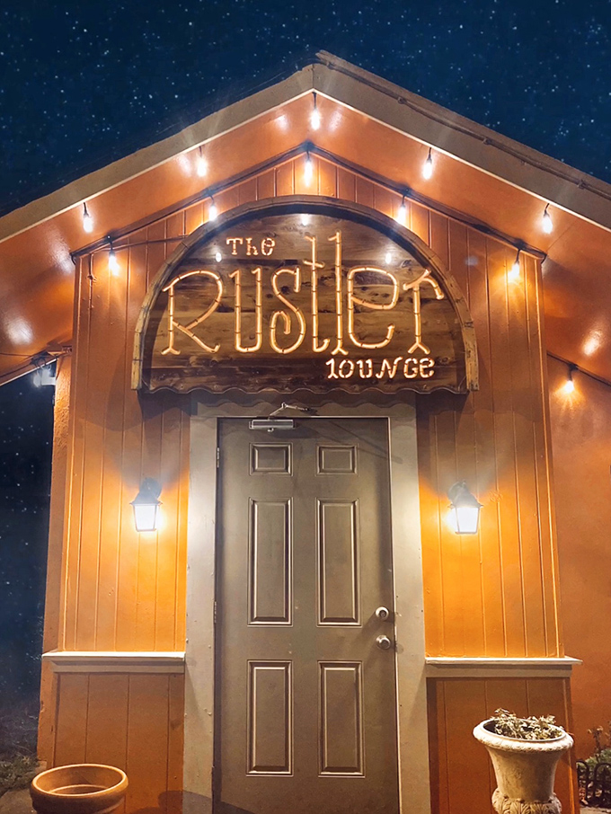 Welcome to The Rustler, where the exterior is as warm and inviting as the prime rib inside. This cozy orange oasis is like a beacon for beef lovers, beckoning you with its twinkling lights and promise of culinary delights.