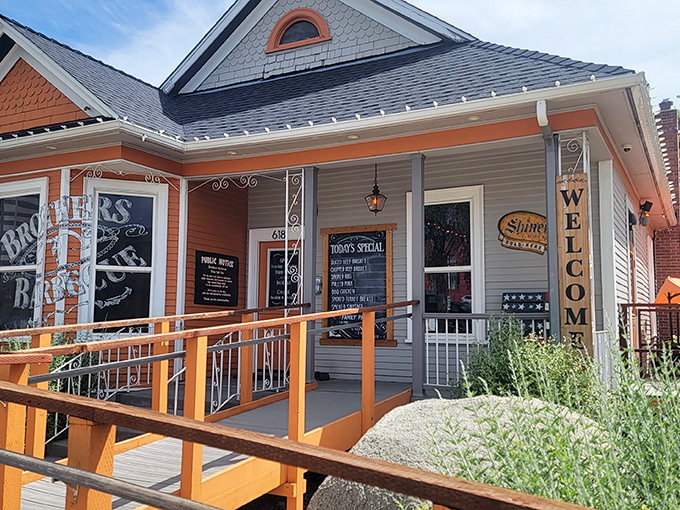 Home is where the smoke signals rise. Brothers Barbecue's charming cottage exterior with its bright orange accents promises comfort before you even step inside.