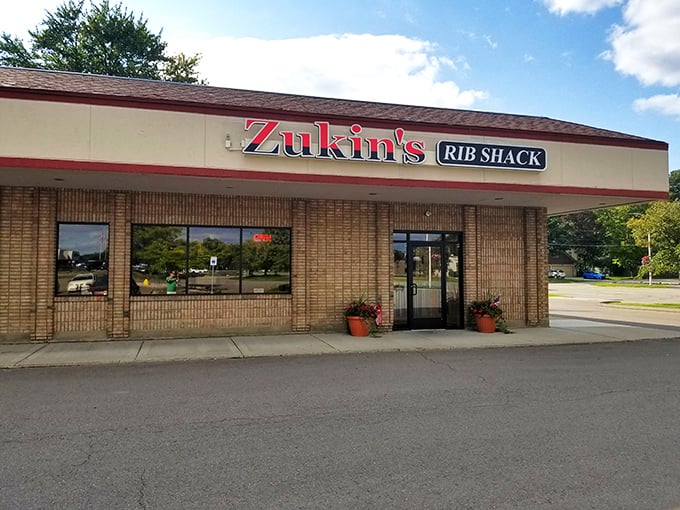Welcome to BBQ paradise! Zukin's Rib Shack stands proud, its red and white sign a beacon of hope for hungry souls seeking smoky salvation.