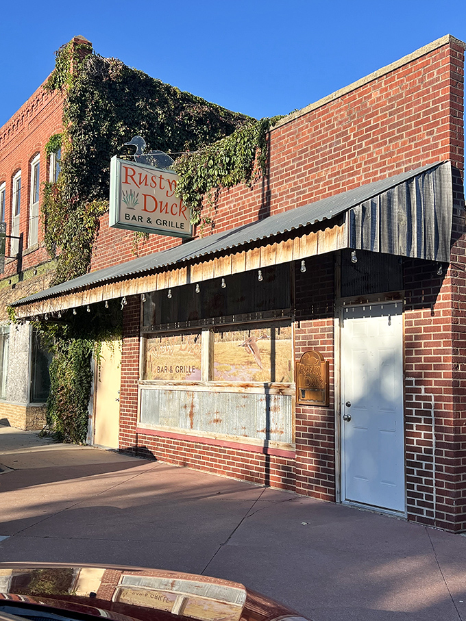 Welcome to the Rusty Duck, where the sign may be weathered, but the steaks are always fresh! This unassuming exterior hides a carnivore's paradise within.