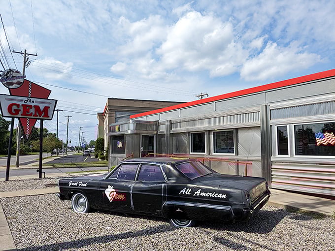 Step back in time! The Gem Diner's gleaming exterior and vintage car are like a portal to the golden age of American diners.