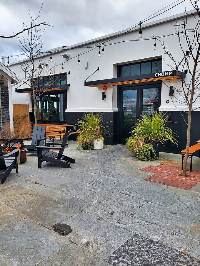 Welcome to burger paradise! Chomp's exterior beckons with its clean lines, inviting patio, and string lights that promise a cozy evening of culinary delights.