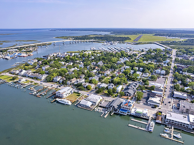 Sunset casts golden light over Beaufort's harbor, where sailboats rest after a day at sea and historic homes stand watch along tree-lined streets.