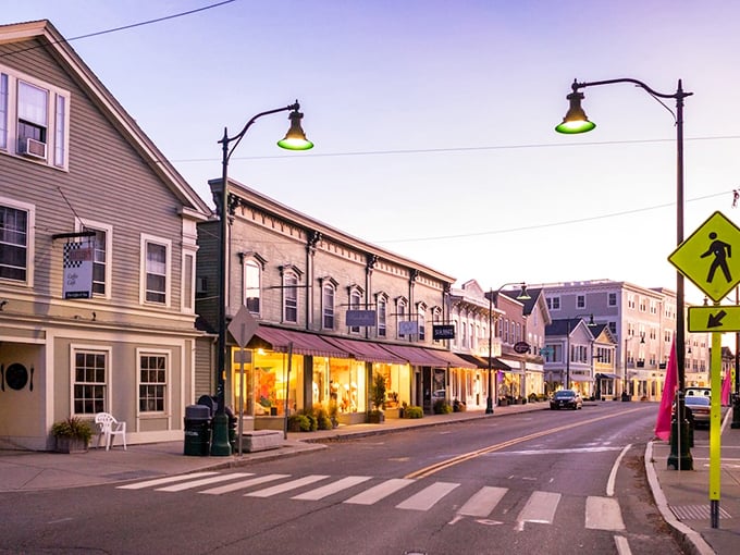 Twilight magic on Main Street! Mystic's charming storefronts glow like fireflies, inviting you to explore their treasures. It's like stepping into a Norman Rockwell painting, only with better shopping options.