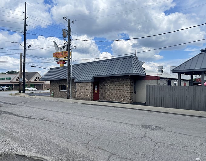 Welcome to flavor town! The Checkered Flag Tavern's iconic sign promises a pit stop for your taste buds, serving up Hoosier hospitality since 1947.