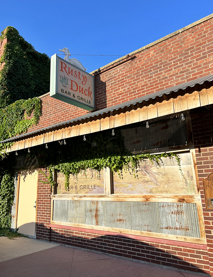 Welcome to the Rusty Duck, where the sign may be weathered, but the steaks are always fresh! This unassuming exterior hides a carnivore's paradise within.