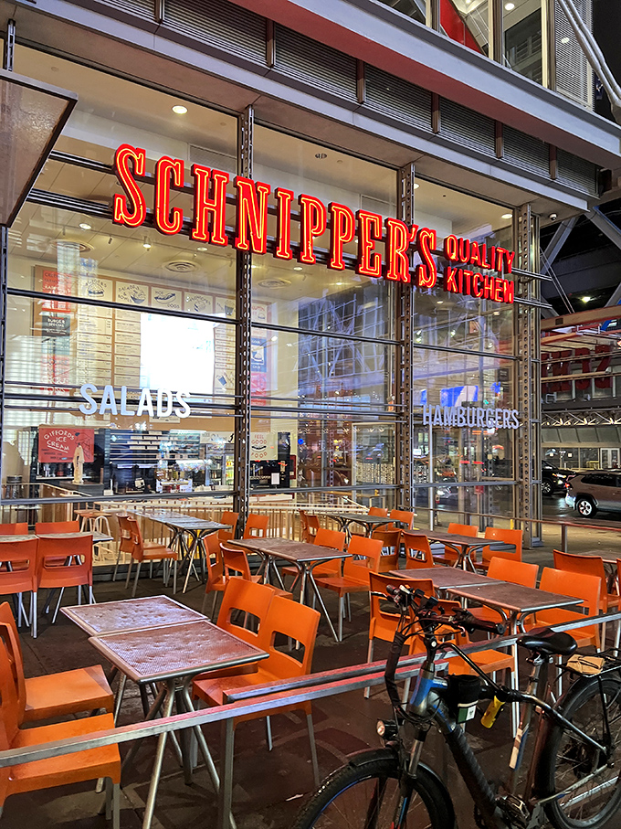 That iconic red Schnipper's sign beckons like a neon promise of comfort food nirvana. The orange chairs outside practically scream "sit here and be happy!"