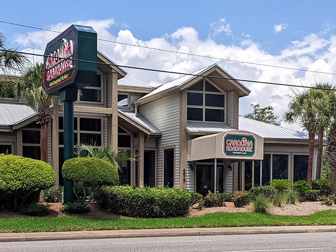 Palm trees stand sentinel alongside the unassuming exterior of Carolina Roadhouse, where culinary treasures await behind that modest "EXIT ONLY" sign.