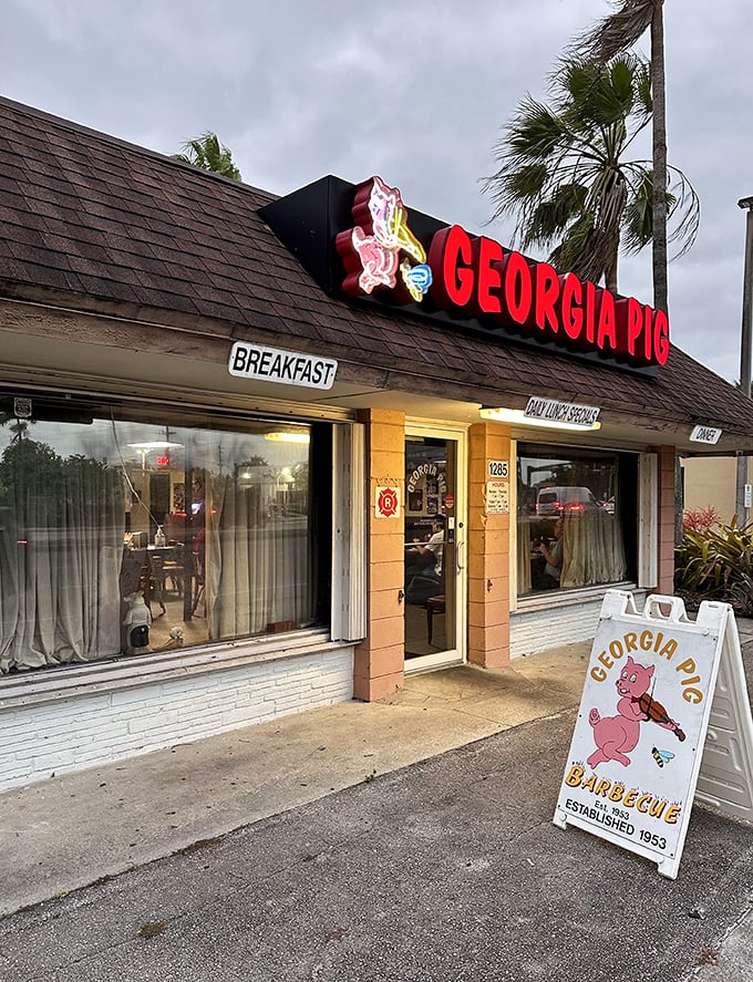 Welcome to pork paradise! The Georgia Pig's neon sign beckons like a beacon of barbecue hope in a sea of chain restaurants.