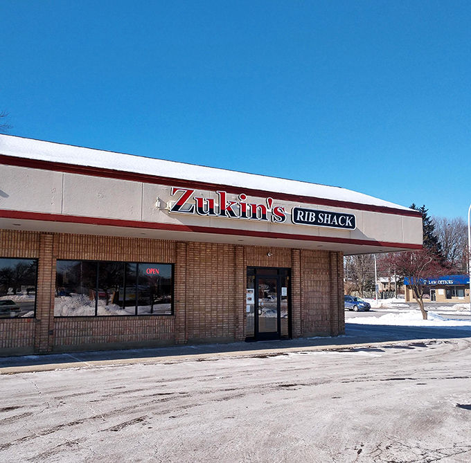 Welcome to BBQ paradise! Zukin's Rib Shack stands proud, its red and white sign a beacon of hope for hungry souls seeking smoky salvation.