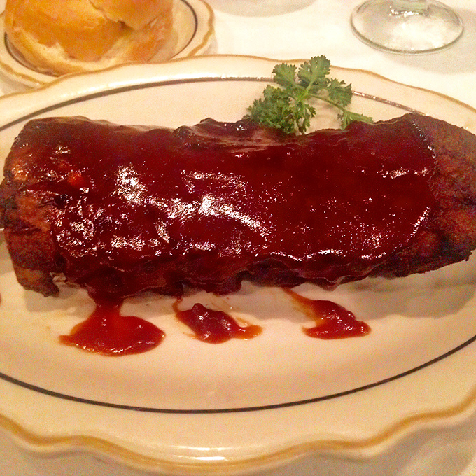 Ribs lacquered with sauce so glossy you could check your reflection before diving face-first into barbecue bliss.