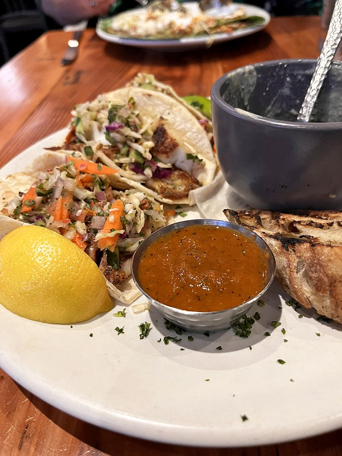 These fish tacos are dressed to impress, with a slaw that brings the crunch and a sauce worth bottling. That lemon means business.