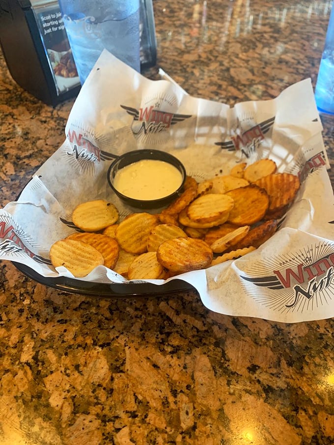 These waffle-cut chips aren't just a side dish; they're golden discs of potato perfection waiting for their cheese sauce companion.