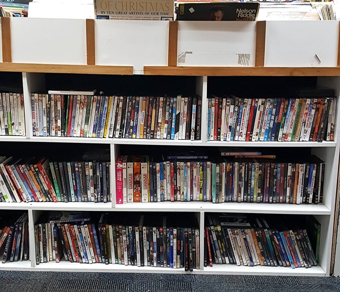 The DVD section: where physical media refuses to die and forgotten films await rediscovery. Three shelves of movies for less than one month of streaming services!