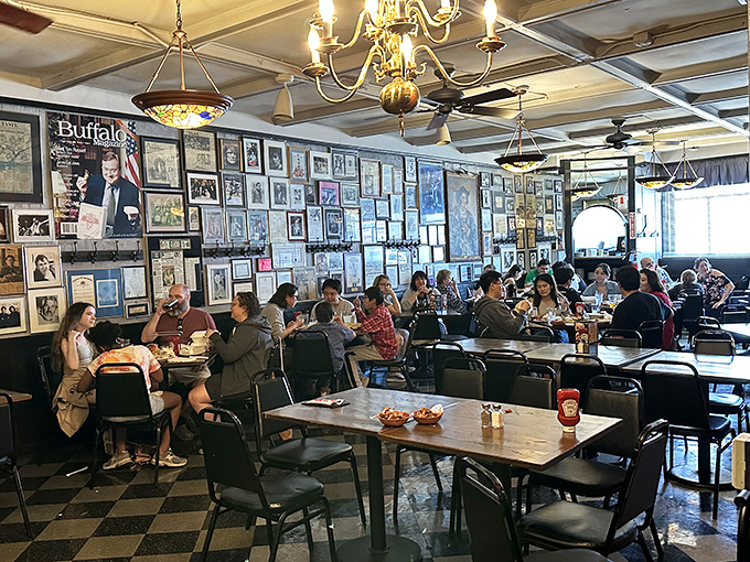 Diners happily crowd the tables beneath walls covered with decades of memorabilia &ndash; each frame telling part of the buffalo wing story.