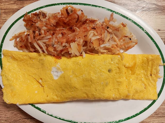 Cheese melting over eggs like a sunrise over the Kansas plains. Those hash browns have achieved the golden-brown perfection that home cooks dream about.