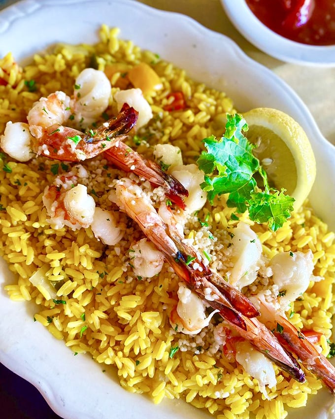 Shrimp scampi on a bed of golden rice. It's like a beach sunset on your plate, but way more delicious.