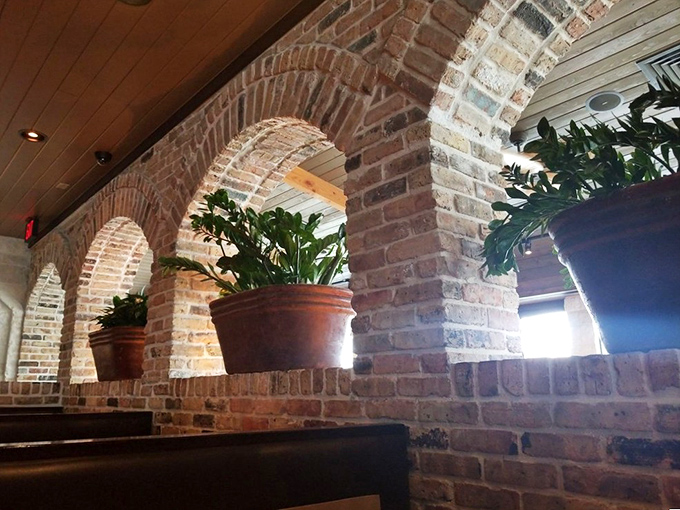 Rustic brick archways divide the space without sacrificing openness, creating cozy dining nooks throughout the restaurant.
