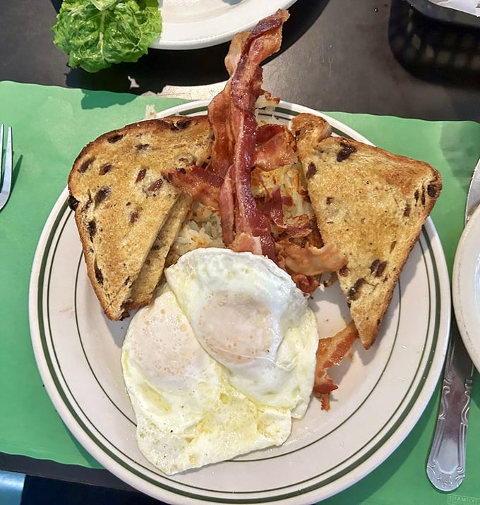 The holy trinity of breakfast: perfectly cooked eggs, bacon with just the right bend, and toast waiting to soak up that golden yolk.