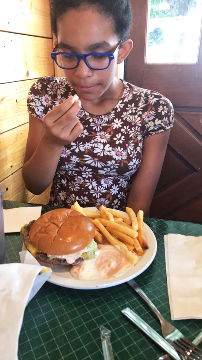 A classic American scene: young diner, meet your match. This burger looks ready to take on any appetite.