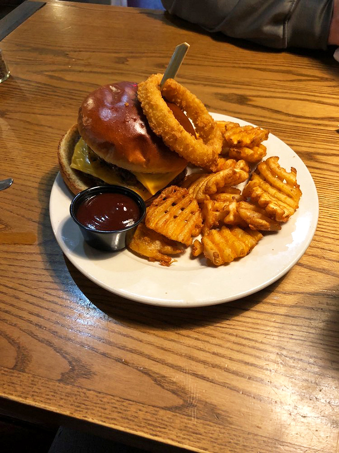 A burger that requires jaw-stretching commitment, paired with waffle fries that deserve their own fan club. Napkins: mandatory.