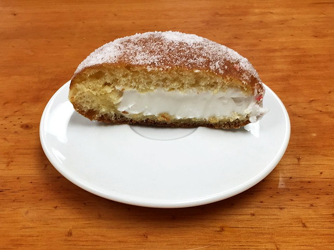 Cream of the crop! This pączki is living its best life, stuffed fuller than your grandma's Thanksgiving turkey.