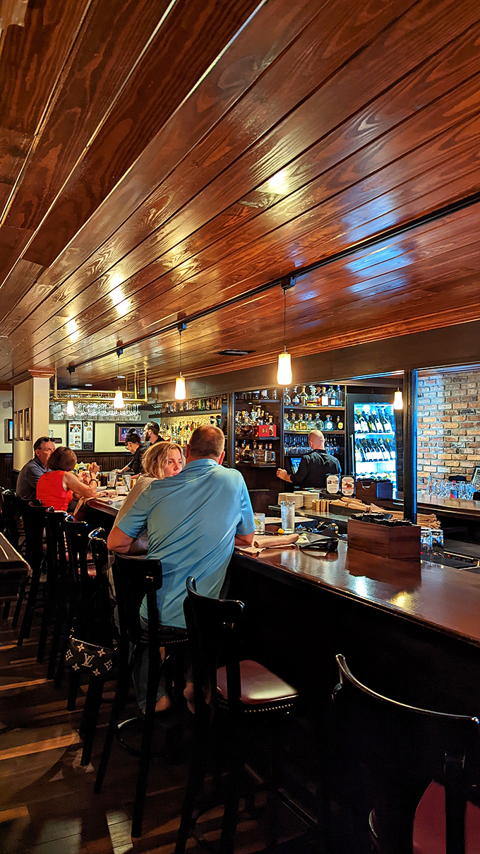 The bar area&mdash;where old-school hospitality meets modern mixology under warm wood ceilings that have absorbed decades of laughter and stories.