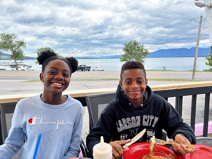 Happy campers alert! These diners are grinning wider than a Montana sky. Must be the pancakes... or the company.
