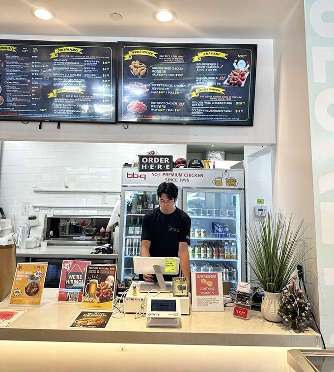 Where the magic happens. The ordering counter promises fulfillment of chicken dreams, with a friendly face ready to guide your journey into Korean fried chicken bliss.