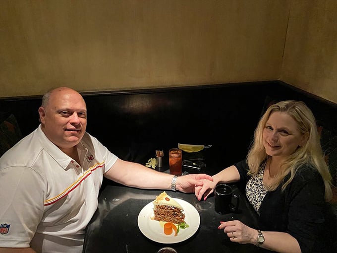The image shows two diners enjoying their meal at a cozy table, their smiles as warm as the ambiance around them.