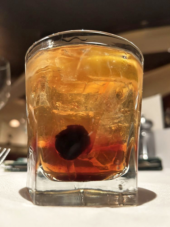 The perfect Old Fashioned: bourbon, bitters, and a cherry nestled in ice like a tiny present waiting to unwrap your evening.