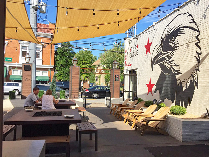 Sun-dappled outdoor seating protected by sail shades, where the urban landscape and comfort food create perfect weekend vibes.