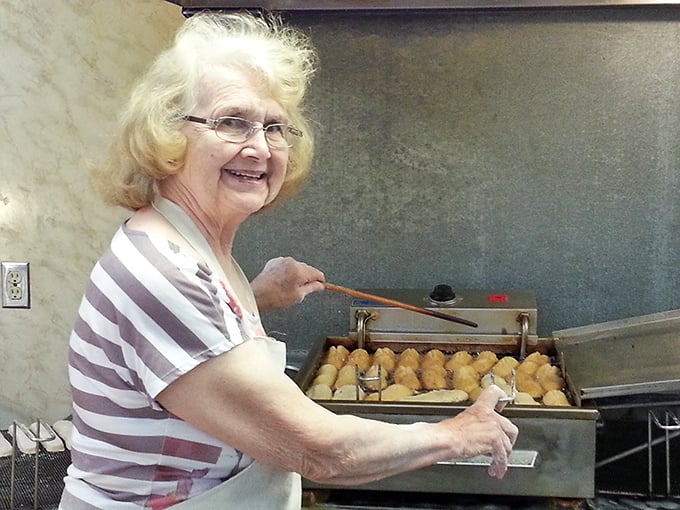 The queen of the donut kingdom, presiding over her delicious domain. Her smile says, "Yes, I know the secret recipe."