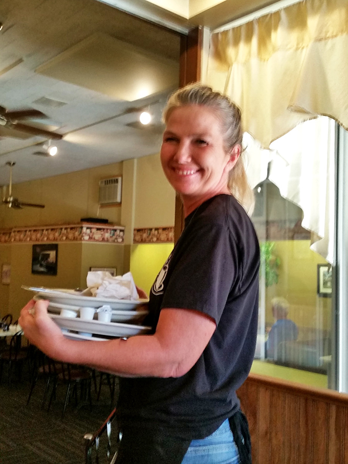 A friendly server carrying plates, ready to make breakfast dreams come true for hungry patrons.