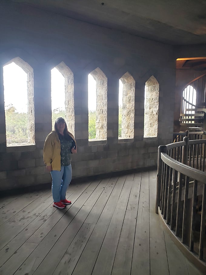 "I'm the queen of the castle!" This visitor strikes a pose, channeling her inner medieval royalty amidst arched windows.
