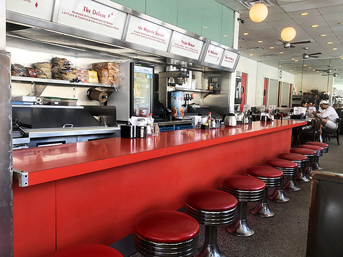 Where the magic happens! This gleaming counter is like mission control for deliciousness, with red stools awaiting eager diners ready to blast off into flavor country.