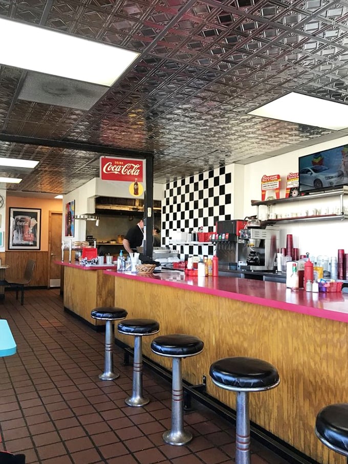 The counter where breakfast dreams come true. Those stools have supported generations of Kansans starting their day right. Notice the classic Coca-Cola signage watching over it all.