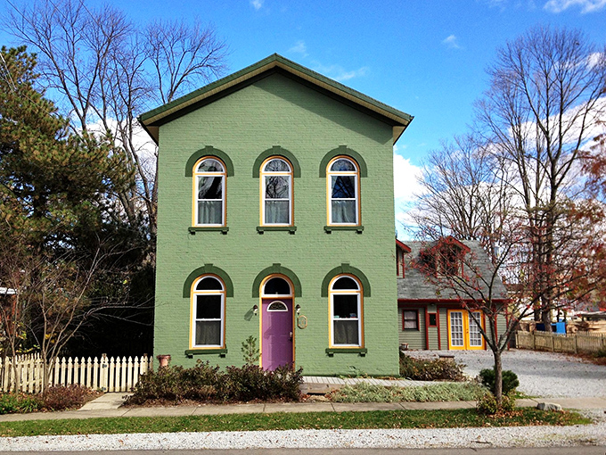 This mint-green Victorian with its purple door is what happens when a dollhouse grows up and decides to make a statement.